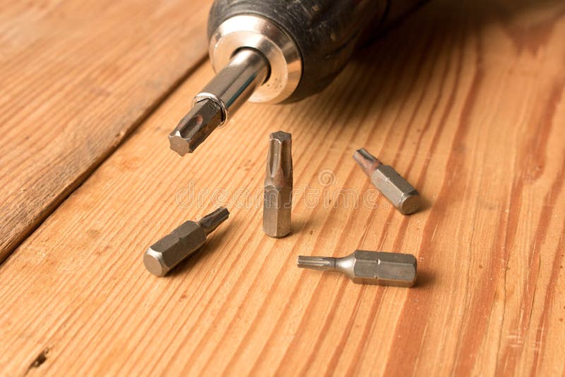 Screwdriver and a Set of Bits on a Wooden Table. the Concept of Stock ...