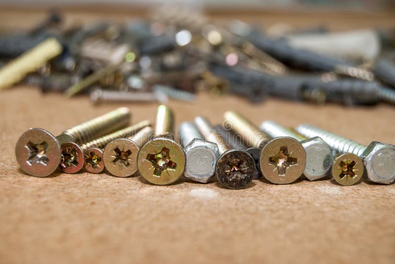 Screws on a wooden table stock photo. Image of metallic - 54622044
