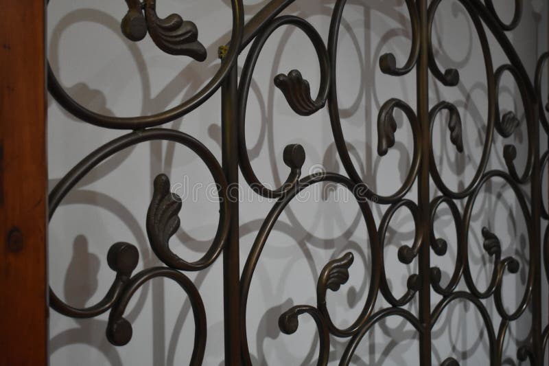 Close-up of a Black-Colored Metal Scroll Headboard Against a White Wall ...