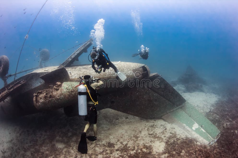 SCUBA Divers Explore the Wreck of an Aircraft Stock Image - Image of ...
