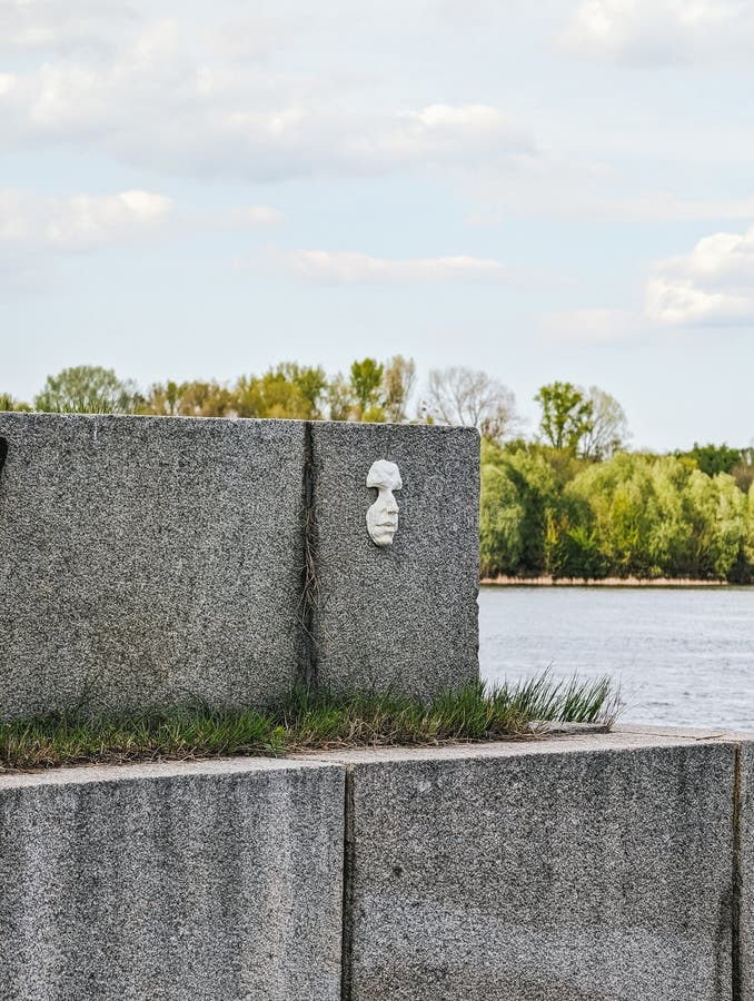 Sculptural Face Design Mounted on Stone Structure by River, Greenery in ...