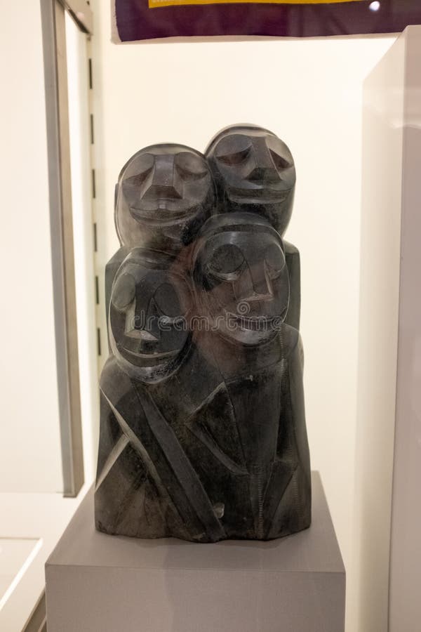 Sculpture Featuring Four Stylized Human Faces, British Museum, Uk Stock ...