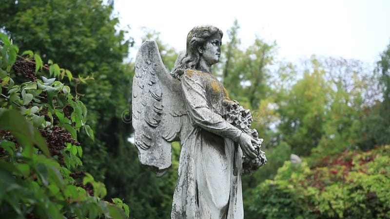 A Sculpture of an Angel Sitting on Stone Steps with Wings Unfolded ...