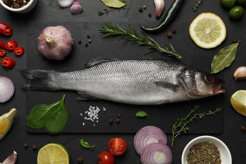 Sea Bass Fish and Ingredients on Black Table, Flat Lay Stock Image ...