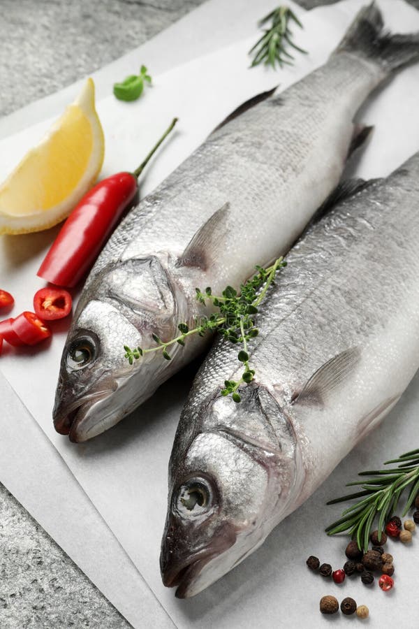 Sea Bass Fish and Ingredients on Grey Table, Closeup Stock Photo ...