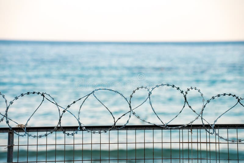 Sea behind barbed wire stock photo. Image of steel, escape - 293167462
