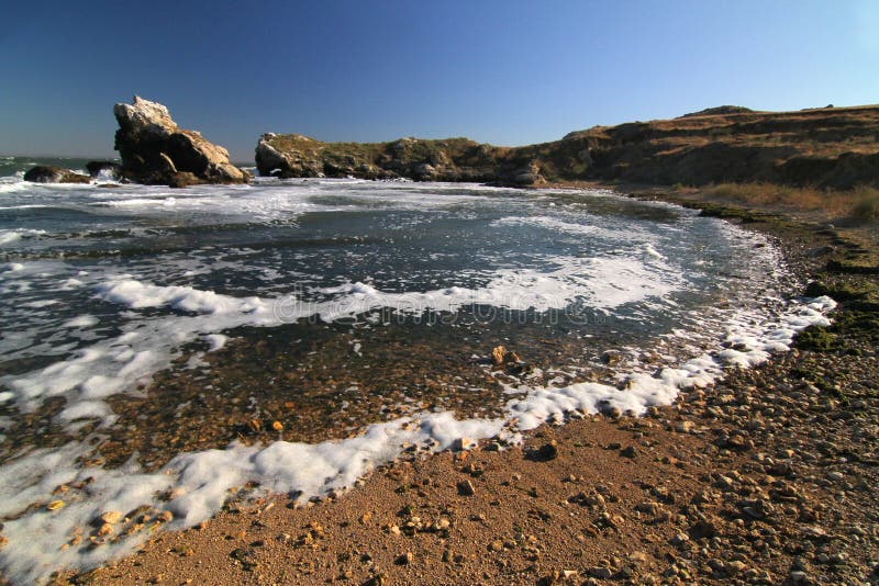 Sea Remote Bay with Rocks and Stones. Sea Surf on the Beach in an ...