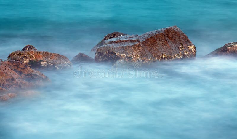 Sea rocks in mist at dusk stock photo. Image of mist - 76608742