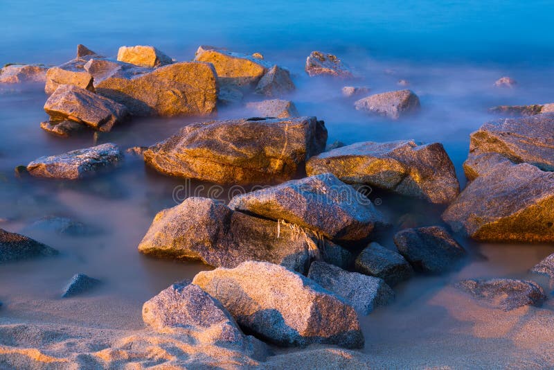 Sea rocks in mist at dusk stock photo. Image of twilight - 94779470