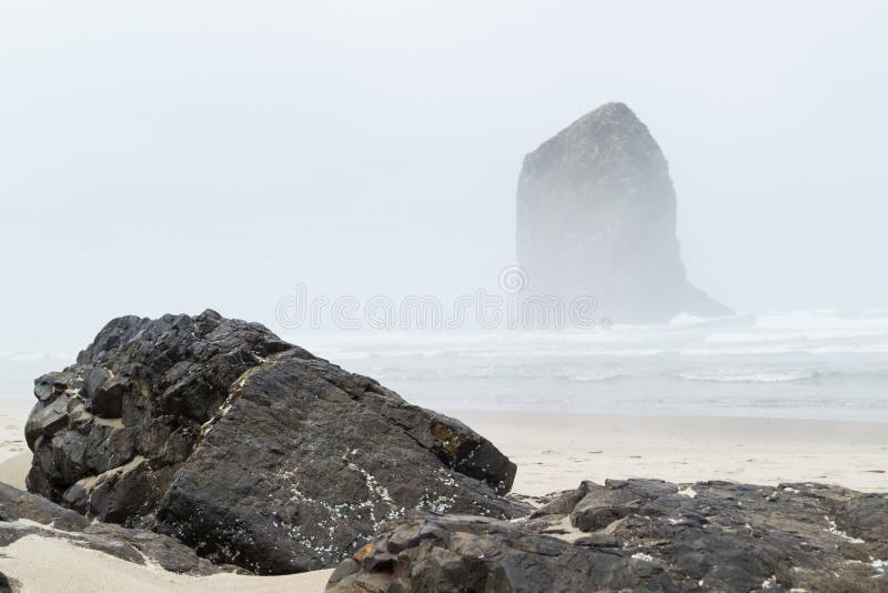 Sea stack in Canon Beach stock image. Image of snow - 261189053