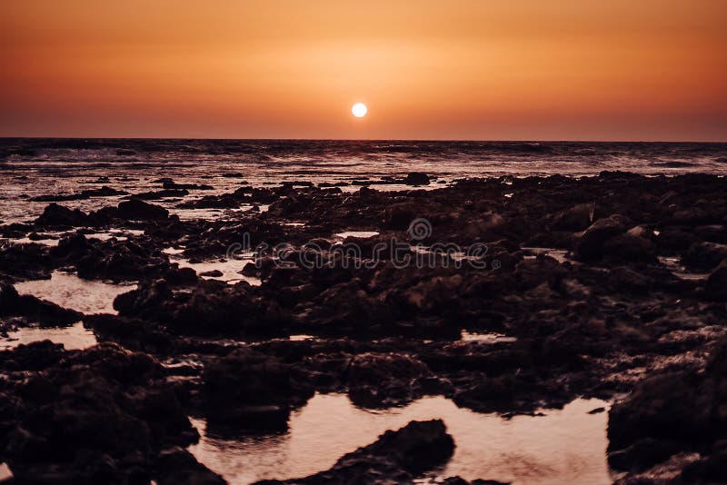 Sea at sunset time stock photo. Image of hitting, rocks - 211616482