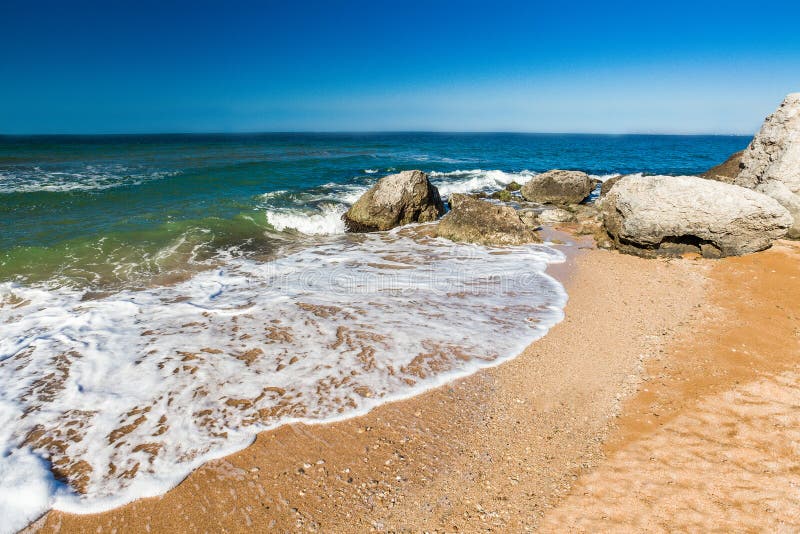 Sea Surf with White Foam on Sandy Seashore with Rocks Stock Photo ...