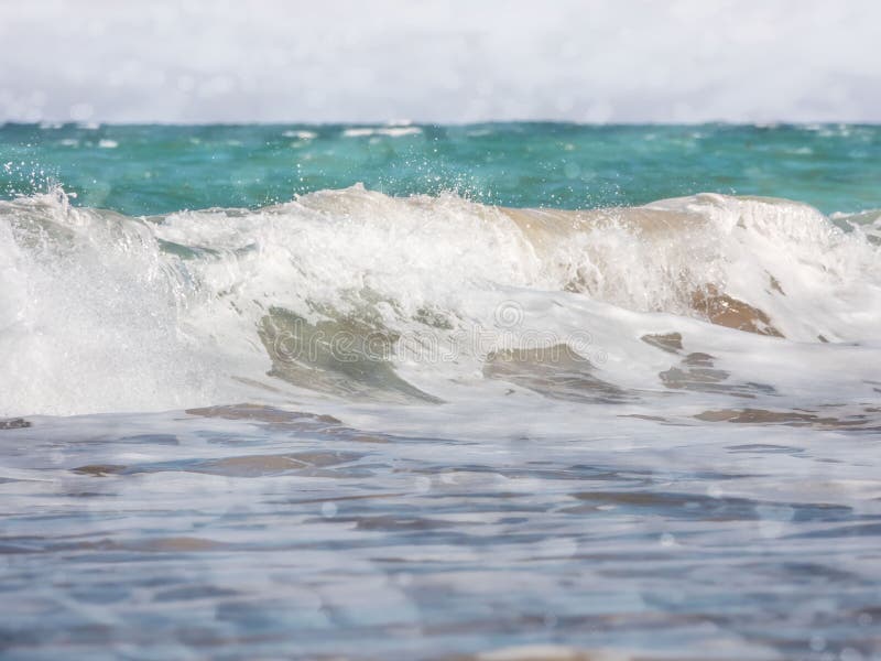 Sea Wave in the Foam Runs into the Sandy Beach with Sun Glare Stock ...