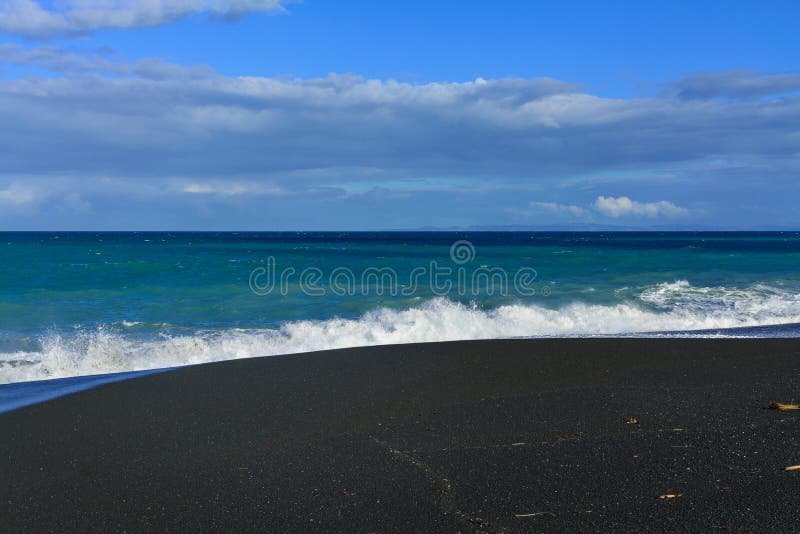 Sea Waves Breaking on a Black Sand Beach. Distant Line of Cargo Ships ...