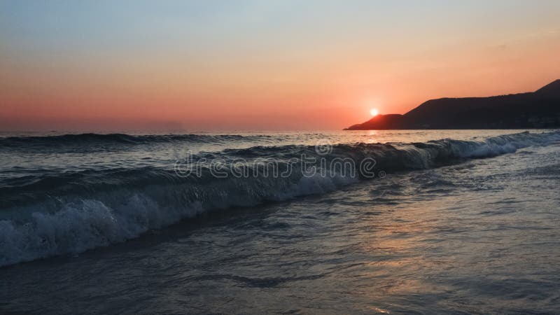 Sea Waves, Sun Sets Behind the Mountains Stock Image - Image of light ...