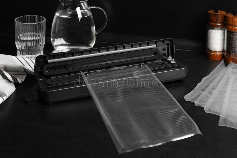 Sealer for Vacuum Packing with Plastic Bags on Black Kitchen Countertop ...