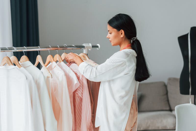 Seamstress is Standing in Her Office that is with Different Clothes ...