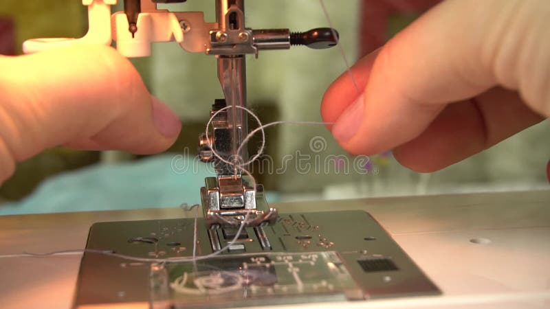 A Seamstress is Threading the Eye of a Needle with a Needle Threader ...