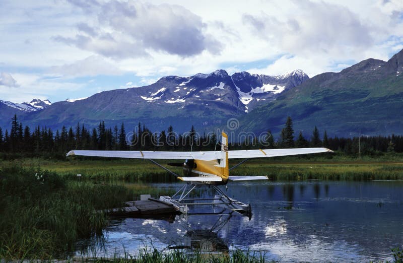 Alaska Float Plane Moored at Dock Amid Foliage Reflections Stock Image ...