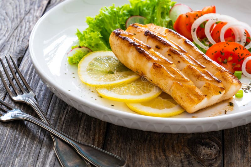 Seared Calamari Steak with Lemon and Fresh Vegetables on Wooden Table ...