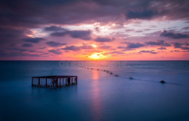 Seascape and Empty Cage at Colorful Sunset Stock Image - Image of ...