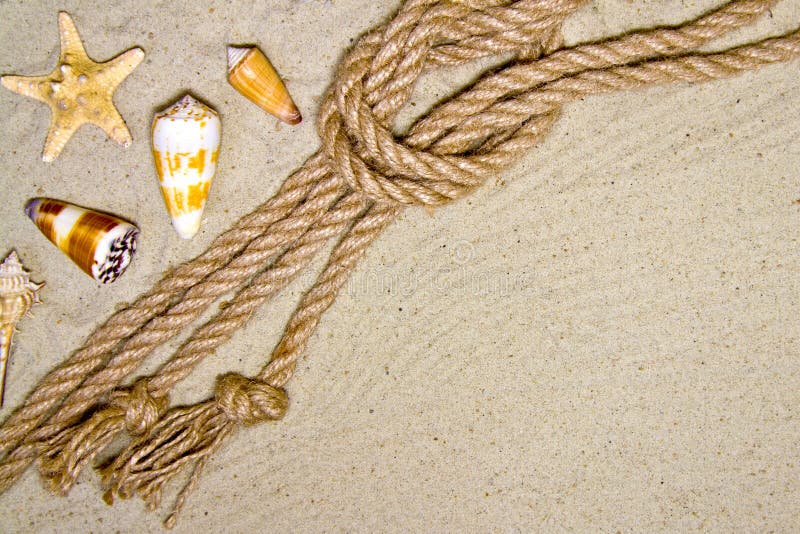 Seashells and Nautical Rope Decoration on Sand Background with Red Toy ...