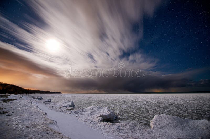 Seashore Covered with Ice Under a Starry Sky with Clouds and Moon Stock ...