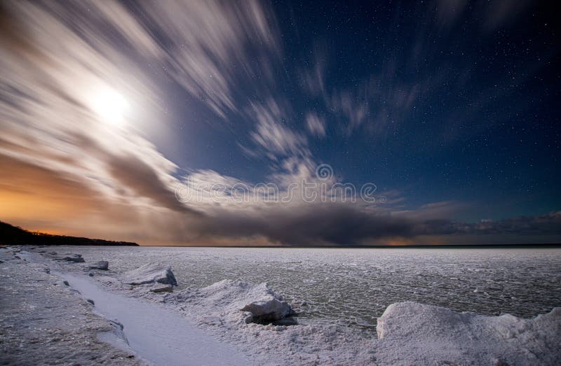 Seashore Covered with Ice Under a Starry Sky with Clouds and Moon Stock ...