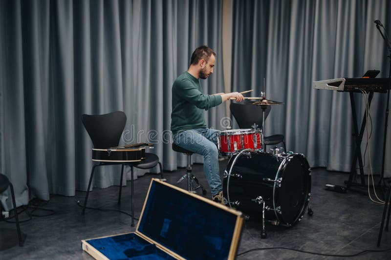 Seated Drummer Practicing at a Studio with Instruments Around Stock ...