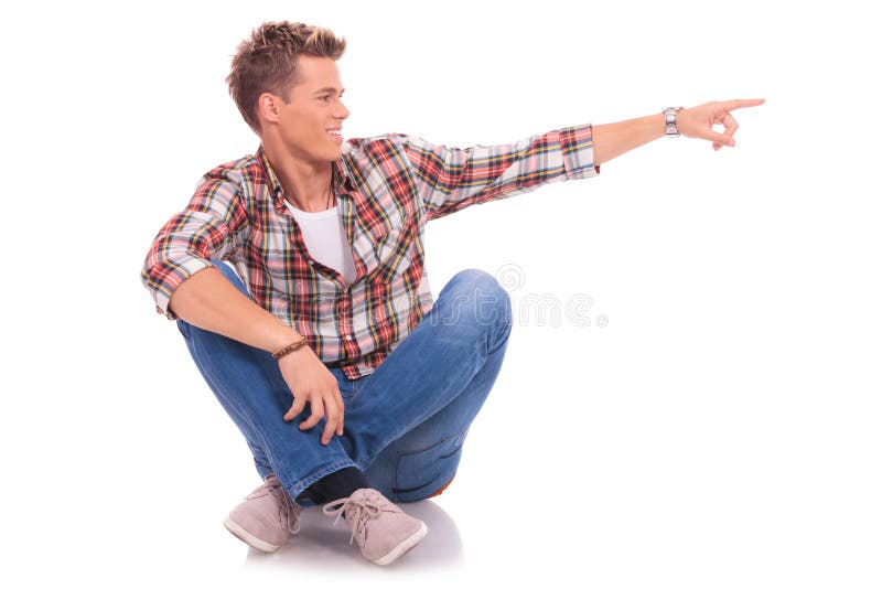 Seated Young Man Pointing To Side Stock Image - Image of happy, latin ...