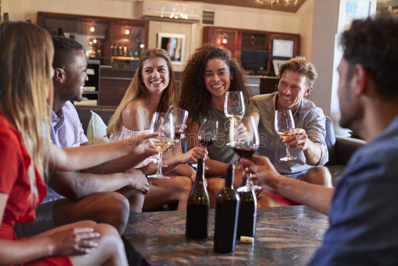 Sechs Junge Erwachsene, Die Einen Toast Mit Wein an Einer Bar Machen ...