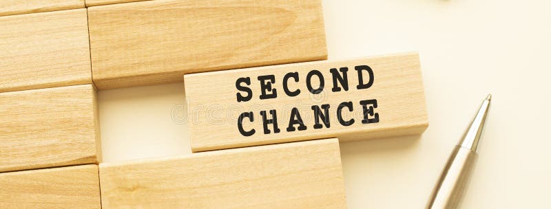 SECOND CHANCE Text on a Strip of Wood Lying on a White Table with a ...