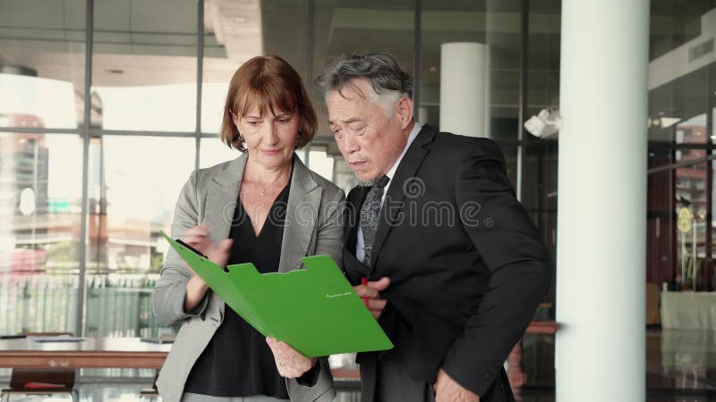 Secretary Giving Document in Folder with Manager Senior Signing about ...