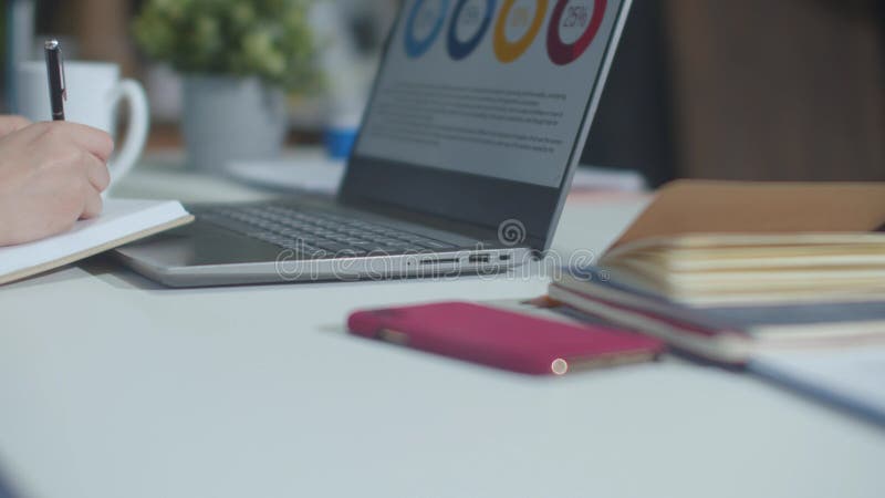 The Secretary Writes a Note and Works with the Laptop Stock Photo ...