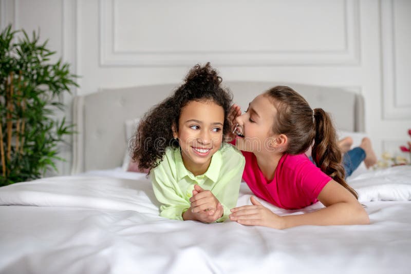 Two Girls Laying on the Bed Sharing Secrets Stock Photo - Image of ...