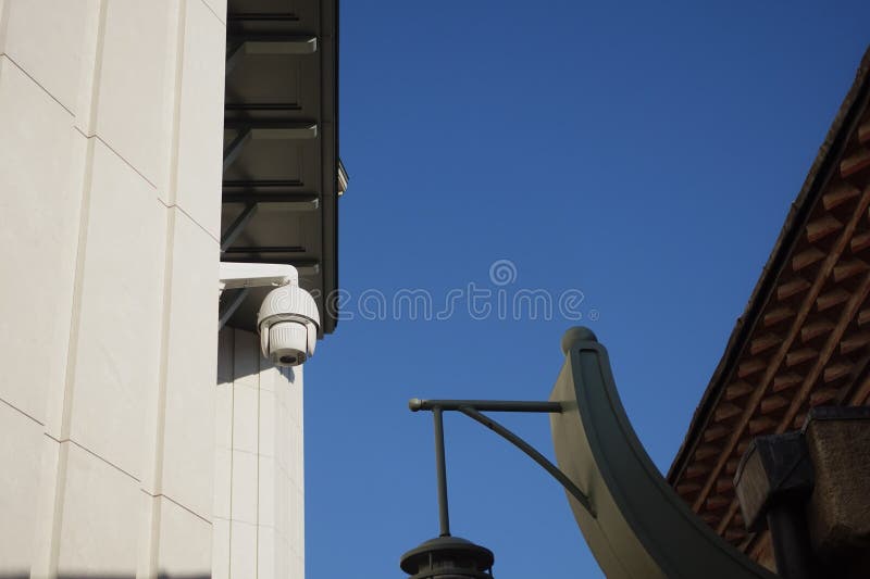 Security Camera Installed on a White Building Under Clear Blue Sky ...