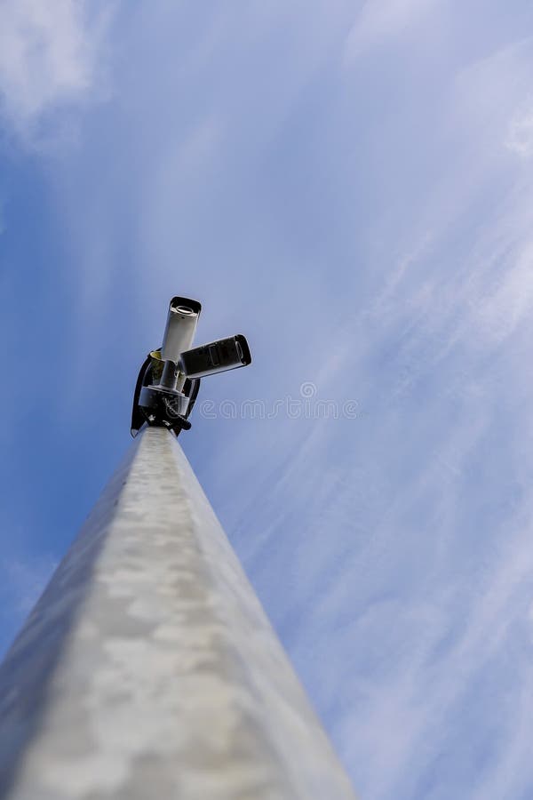 Security Camera on a Metal Post Against Blue Cloudy Sky. View from ...