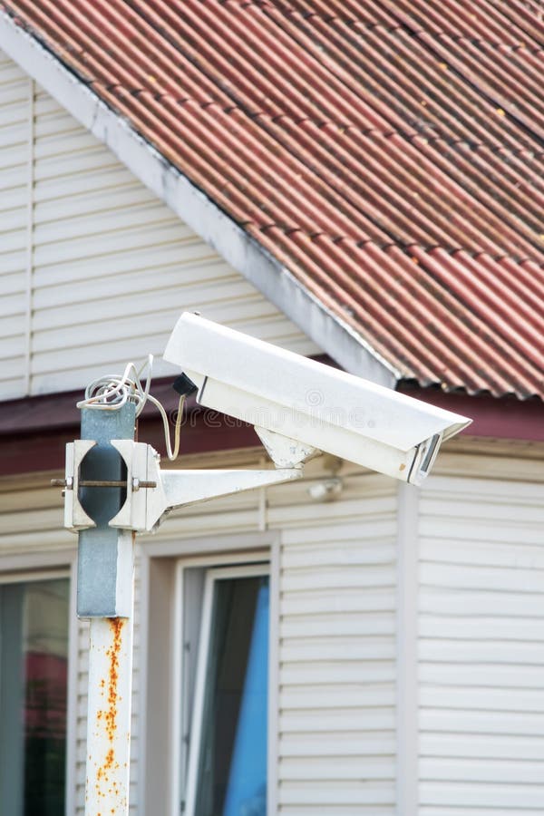 A Security Camera is Mounted on a Tall Pole in Front of a House Stock ...