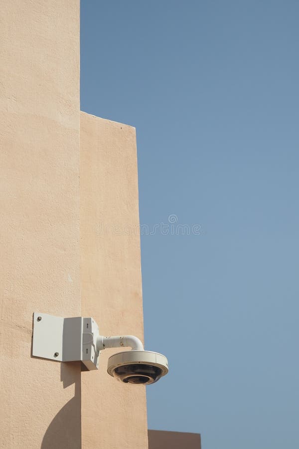 Security Camera Mounted on a Wall Against a Clear Blue Sky Stock Image ...
