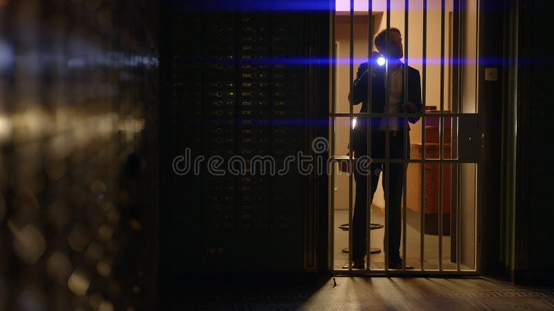 A Security Guard with a Flashlight Conducting Inspections in a Dark and ...