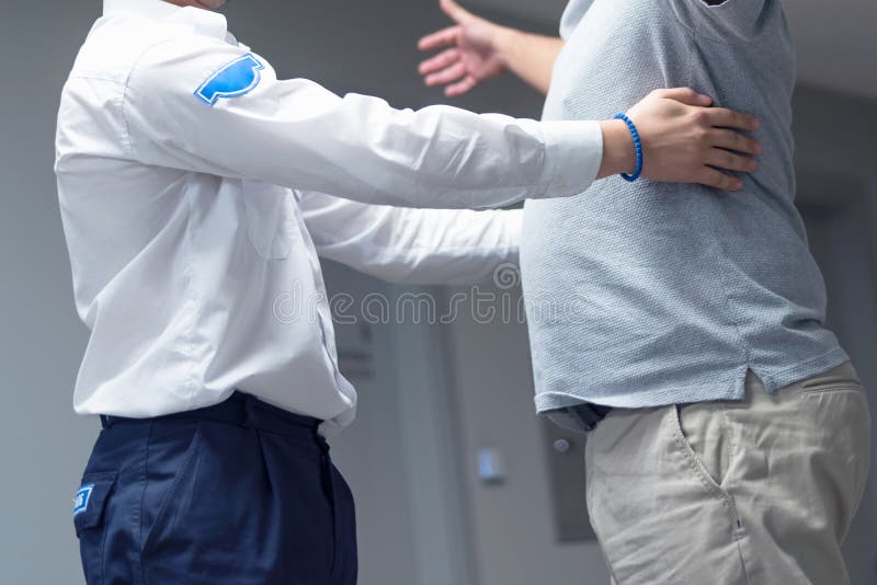 Security Guard Making a Pat-down Procedure for Finding Hidden Objects ...