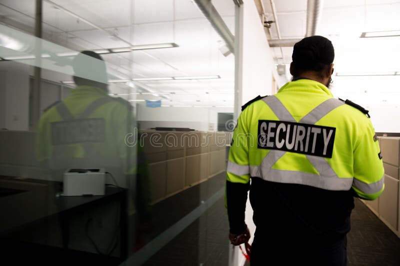 A Security Guard is Patrolling an Office at Night. Stock Photo - Image ...