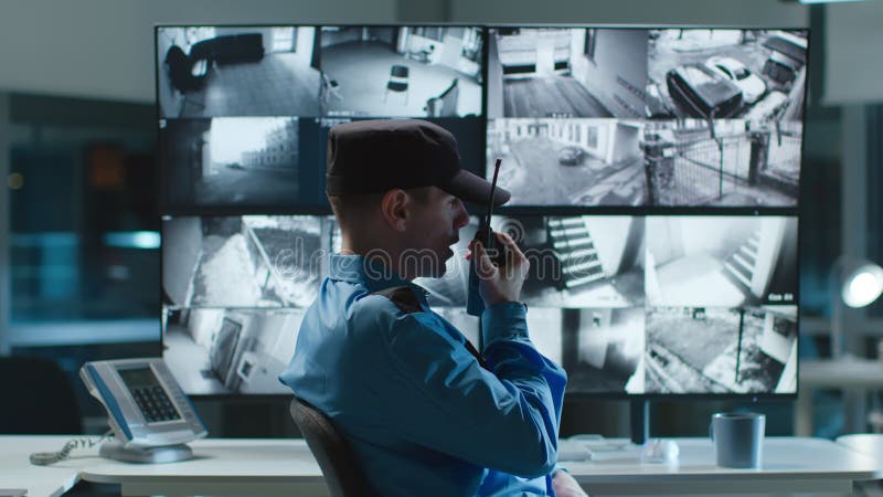 Security Guard Talking on Walkie Talkie while Looking at Cctv Camera ...
