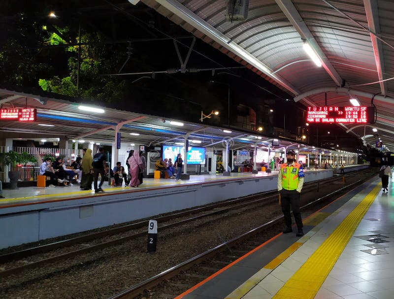 A Security Guard in Uniform with a Vest Stands on the Platform of Train ...