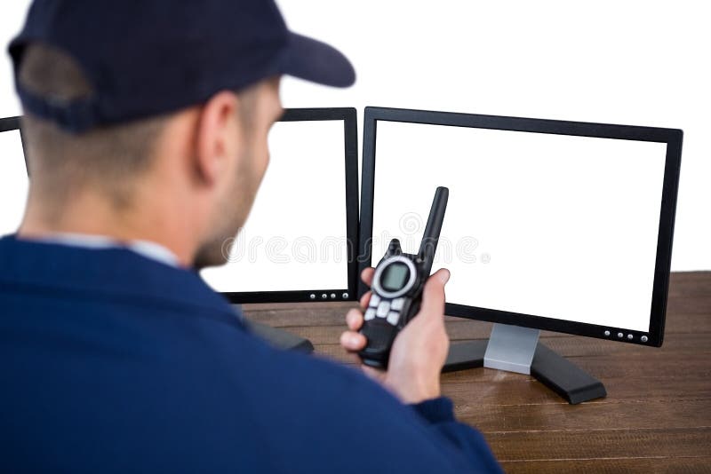 Security Officer Talking on Walkie-talkie while Looking at Computer ...