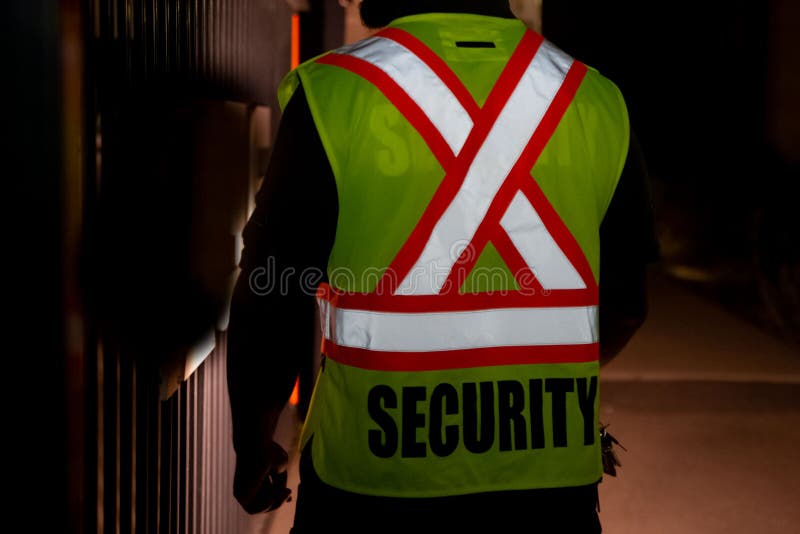 Security Person Standing at the Fence at Night, Shot from Back Stock ...