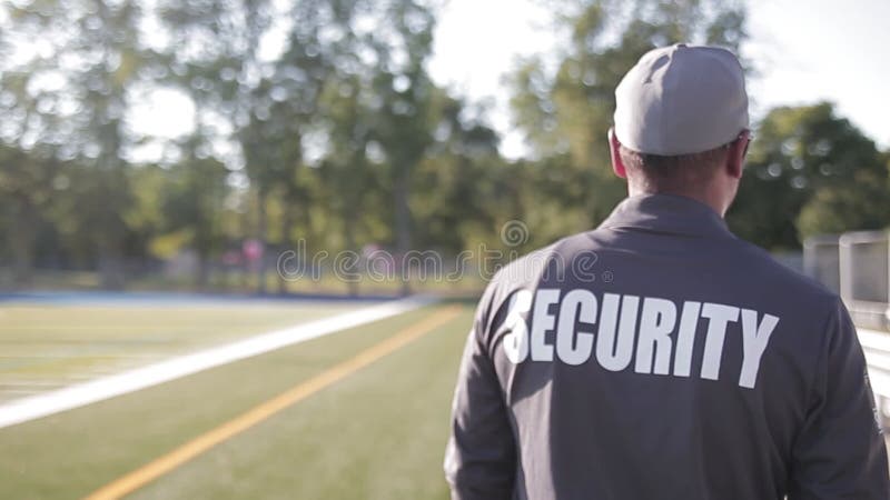Security Person Walking in the Green Field, Shot from Back Stock Video ...