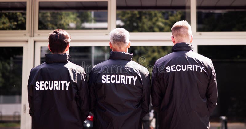 Security Team of Uniformed Guards Stand with Hands Clasped Behind Their ...