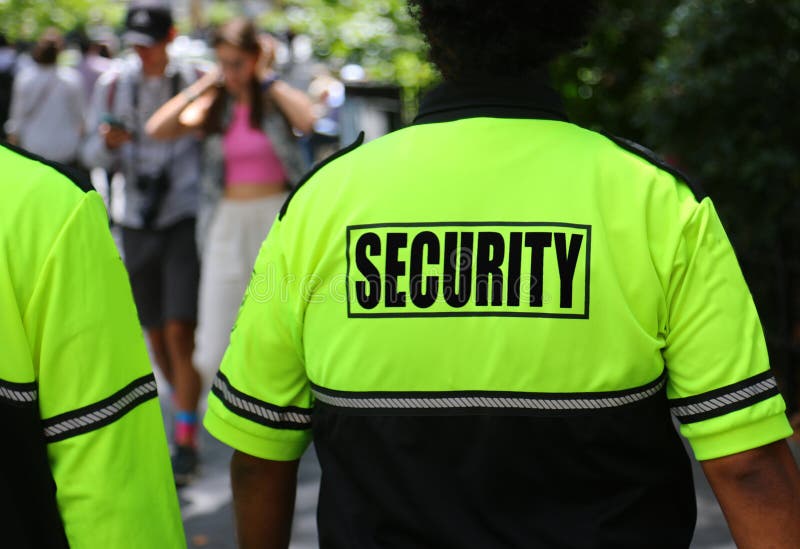 Security Word on the Fluorescent Vest of a Security Guard while ...