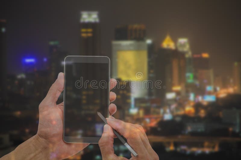 See through of Man`s Hand Holding Mobile Phone on Blurred City Light at ...